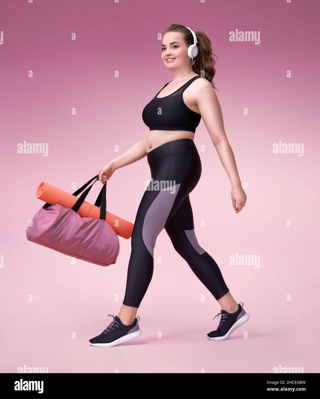 Sporty girl with sports bag, ready to training. Photo of model with ...