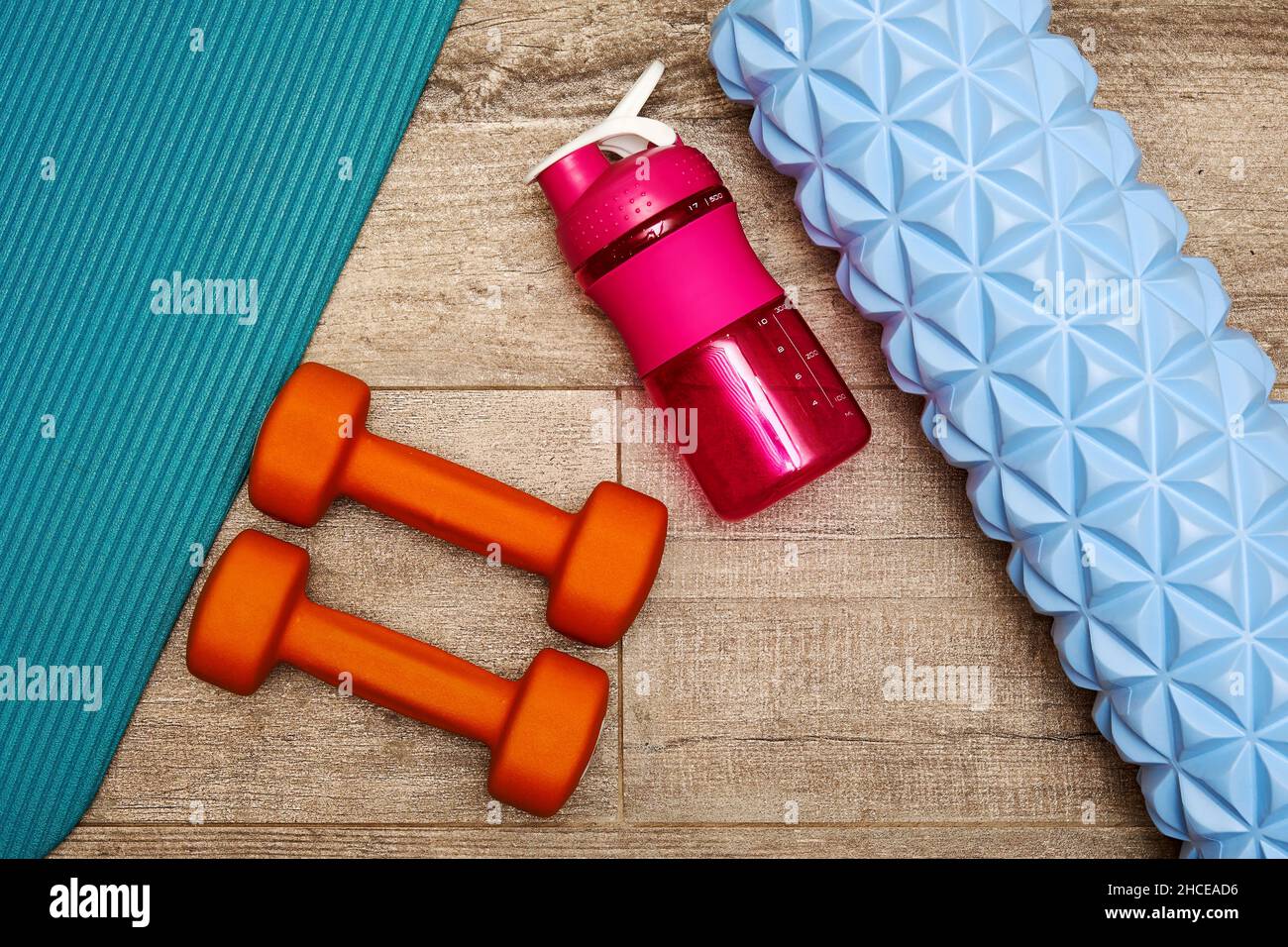 Small fitness dumbbell and roller on the floor in the gym. Healthcare ...