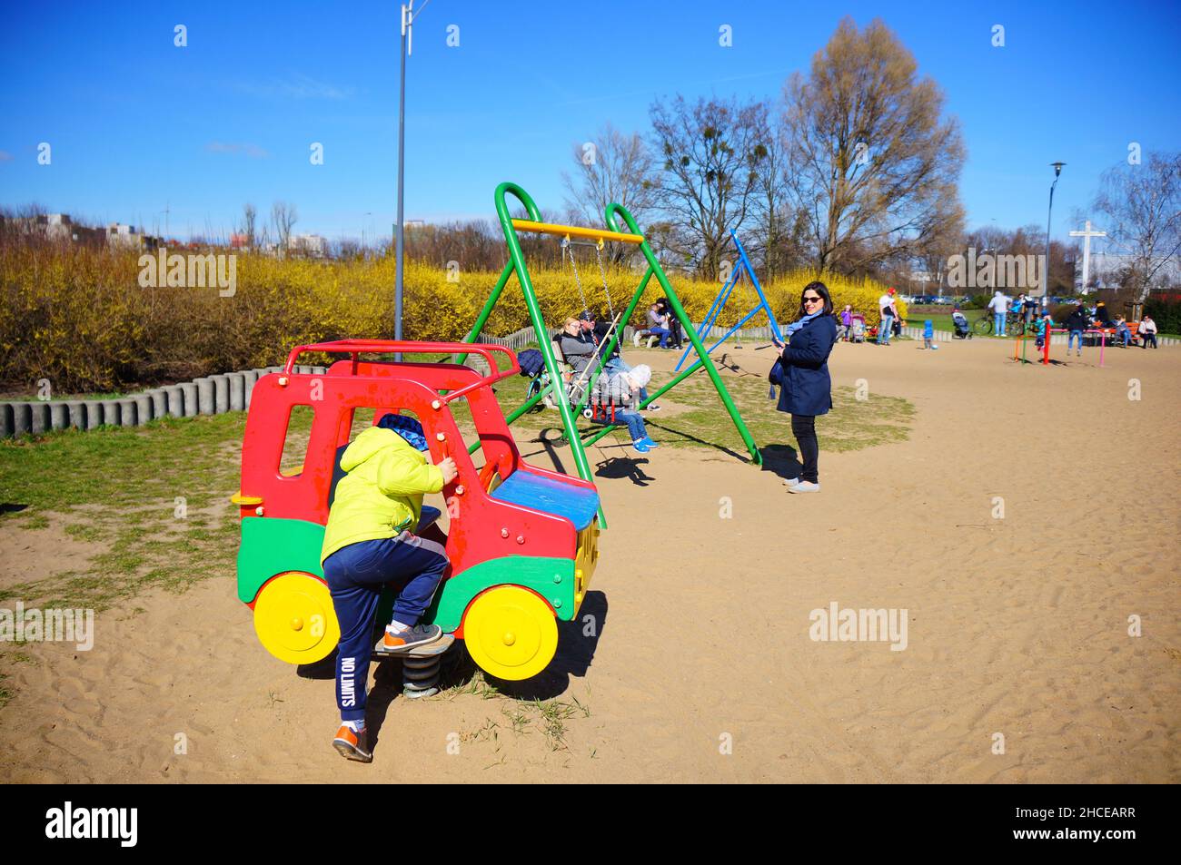 Boy climbing in a car spring swing at a playground in the Jan Pawla ...