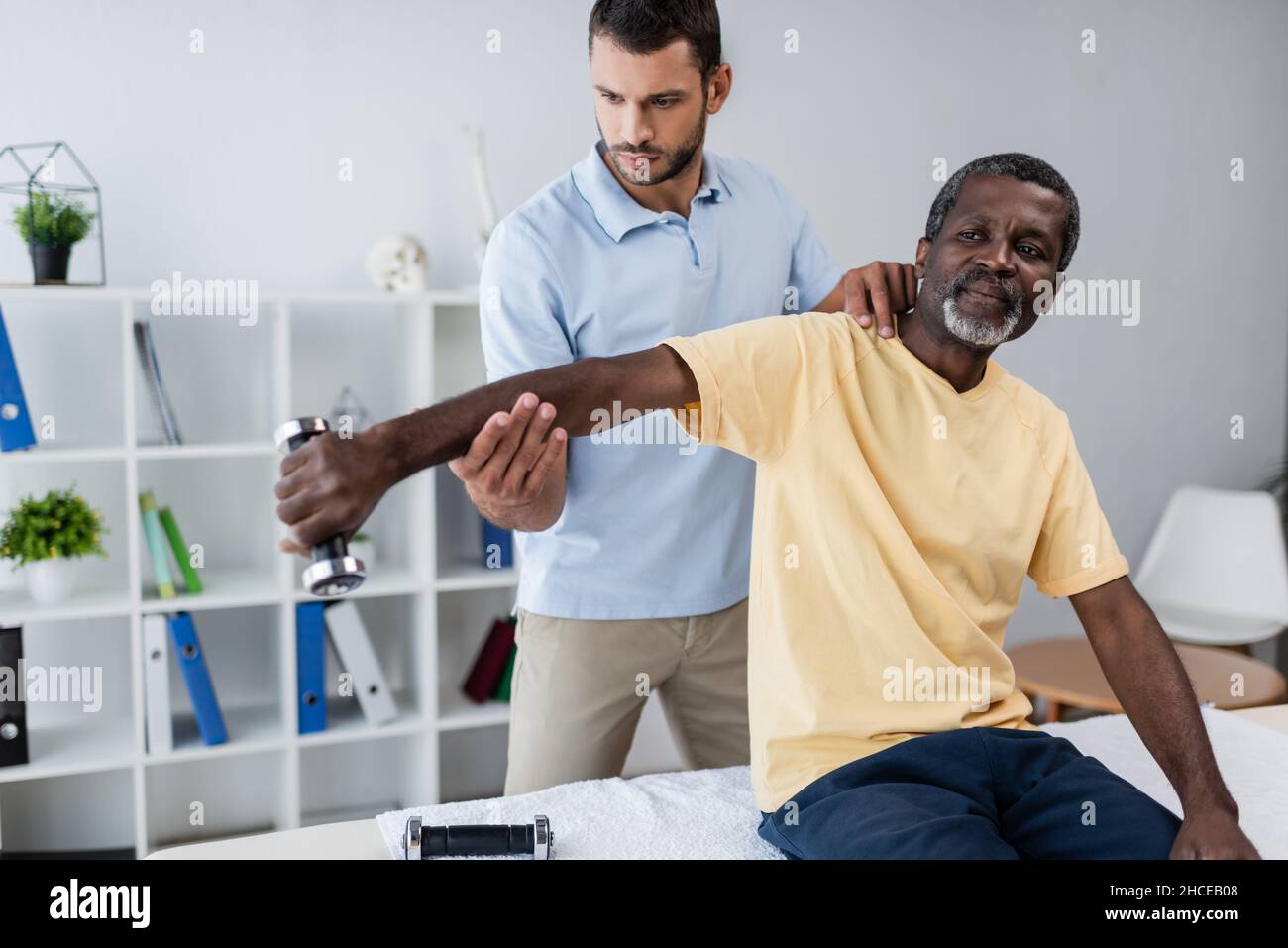 hospital trainer assisting mature african american patient training ...
