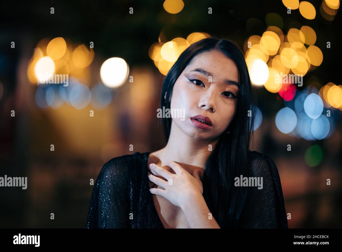 Portrait of Young Asian man on the street at night with lights in the ...