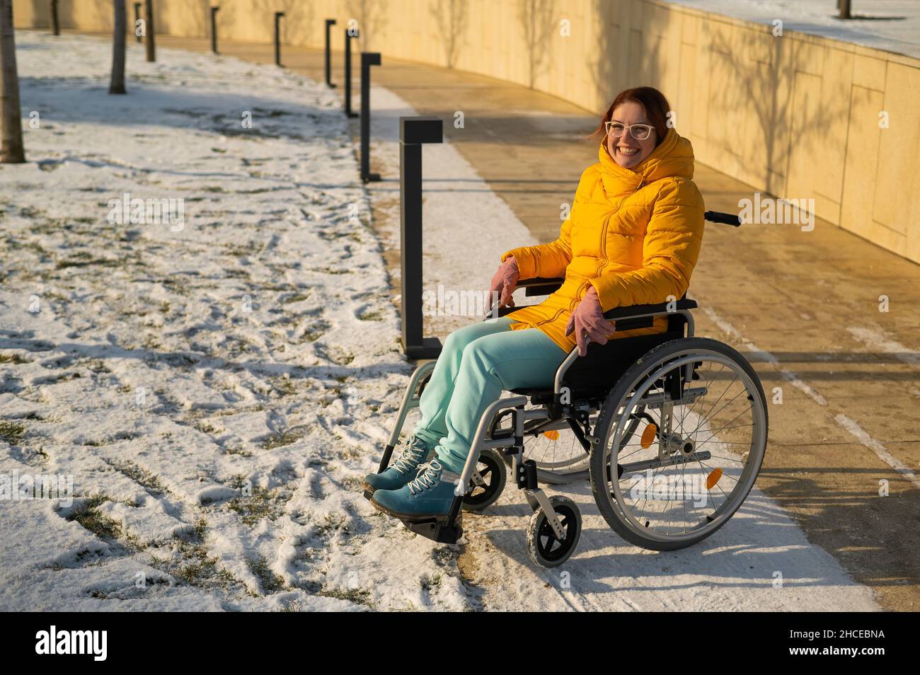 Caucasian woman with disabilities rides on a chair in the park in ...