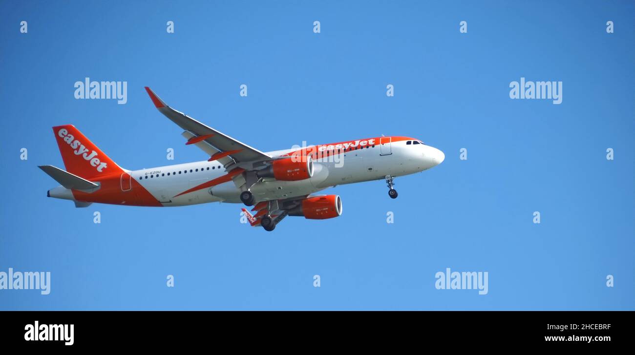 Orange easyJet airplane flying with blue sky Stock Photo - Alamy