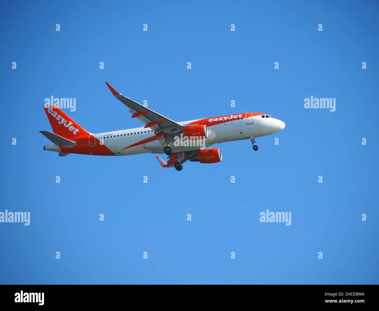 Orange easyJet airplane flying with blue sky Stock Photo - Alamy