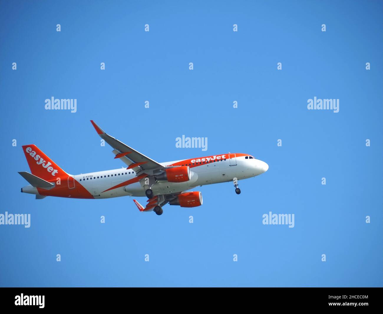 Orange easyJet airplane flying with blue sky Stock Photo - Alamy