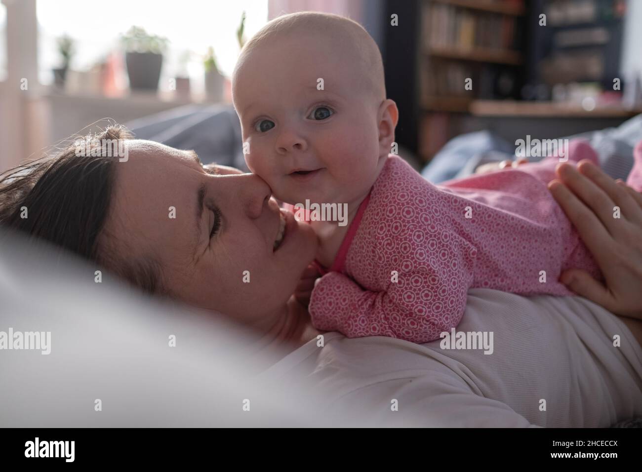 Happy loving caucasian mother spending time, playing with baby girl ...