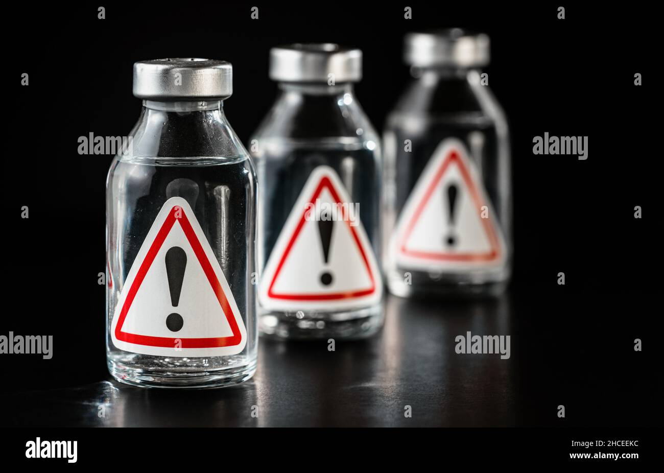 Three vaccine bottles with red triangle exclamation mark sign on label ...