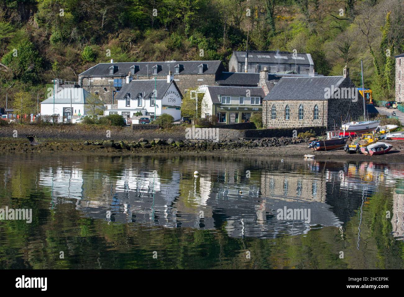 View of Tobermory harbour showing the whisky distillery and reflections ...