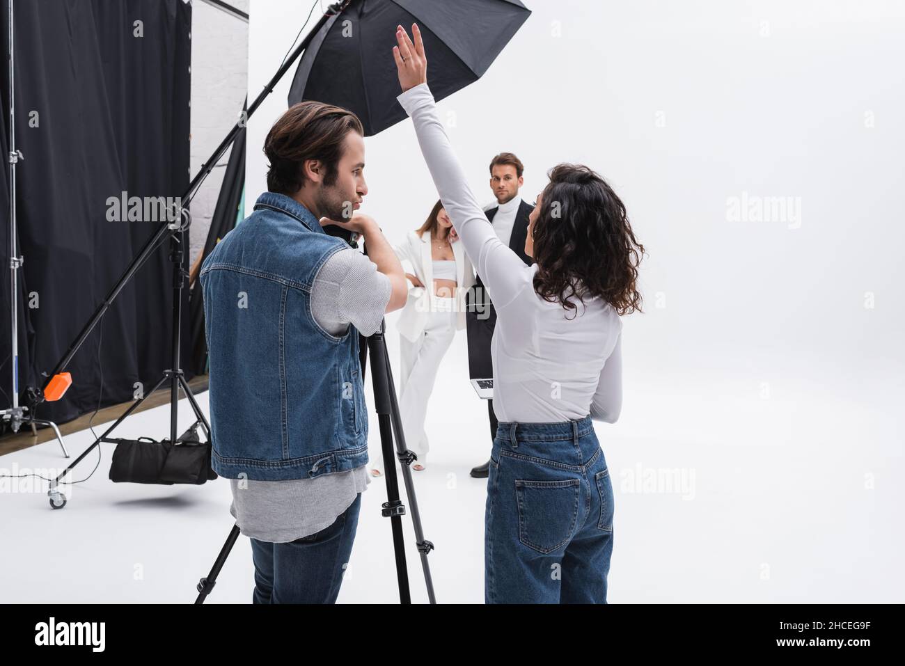 art director standing with raised hand while talking to photographer ...