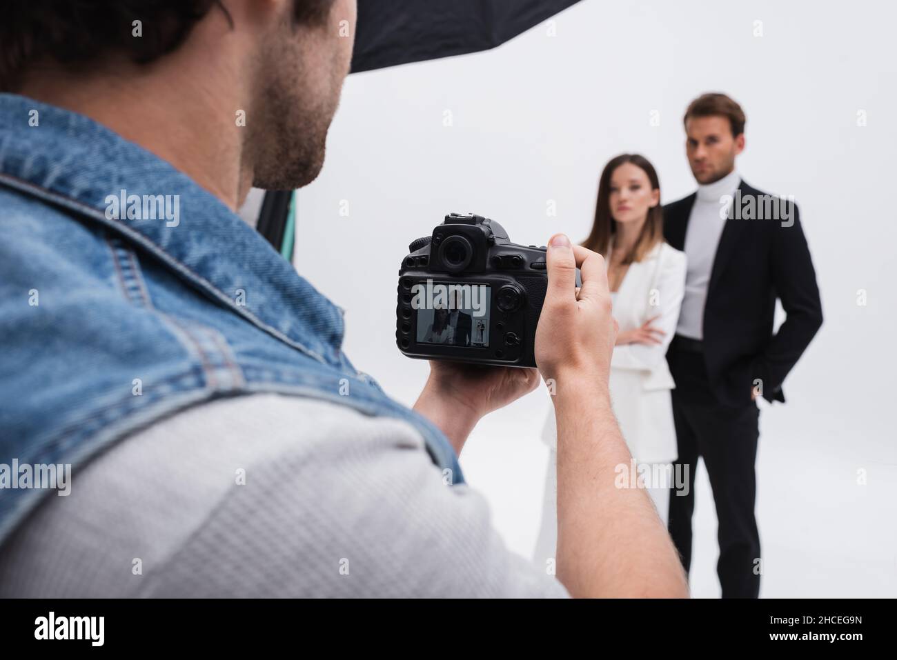 professional photographer taking photo of blurred models on white Stock ...