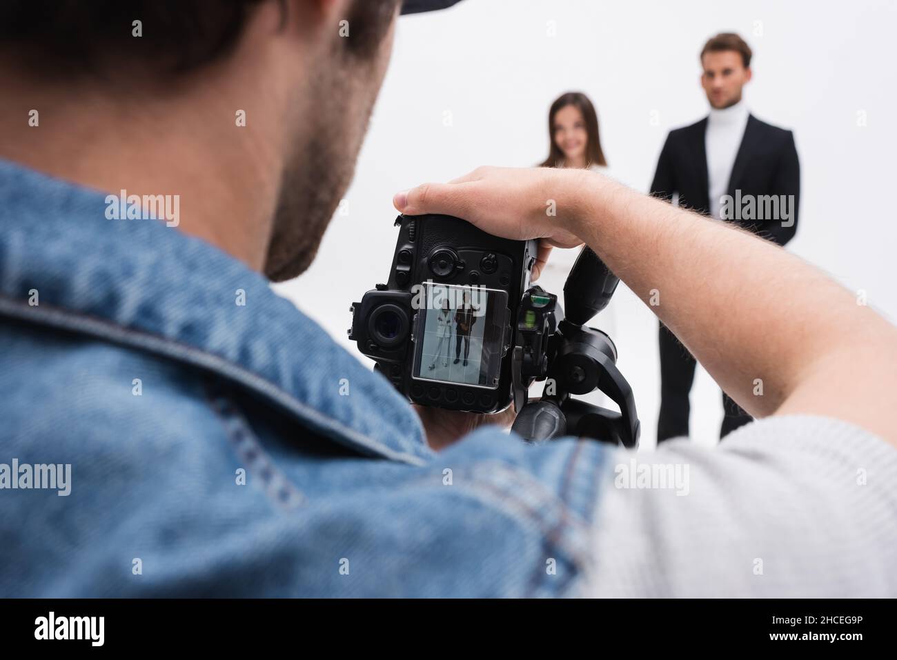 photographer with digital camera taking photo of blurred models ...