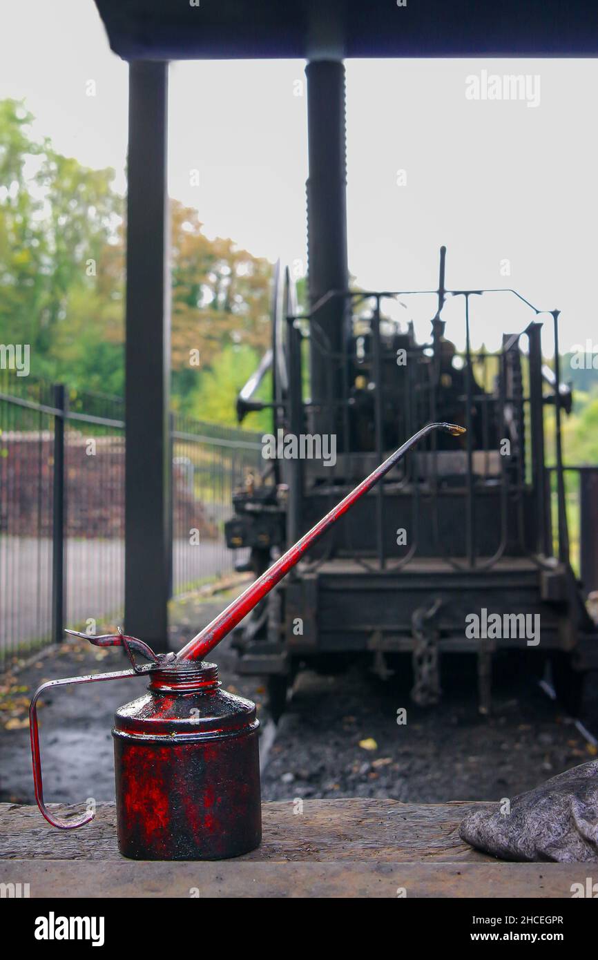 Red oil can in front of an old steam engine Stock Photo - Alamy