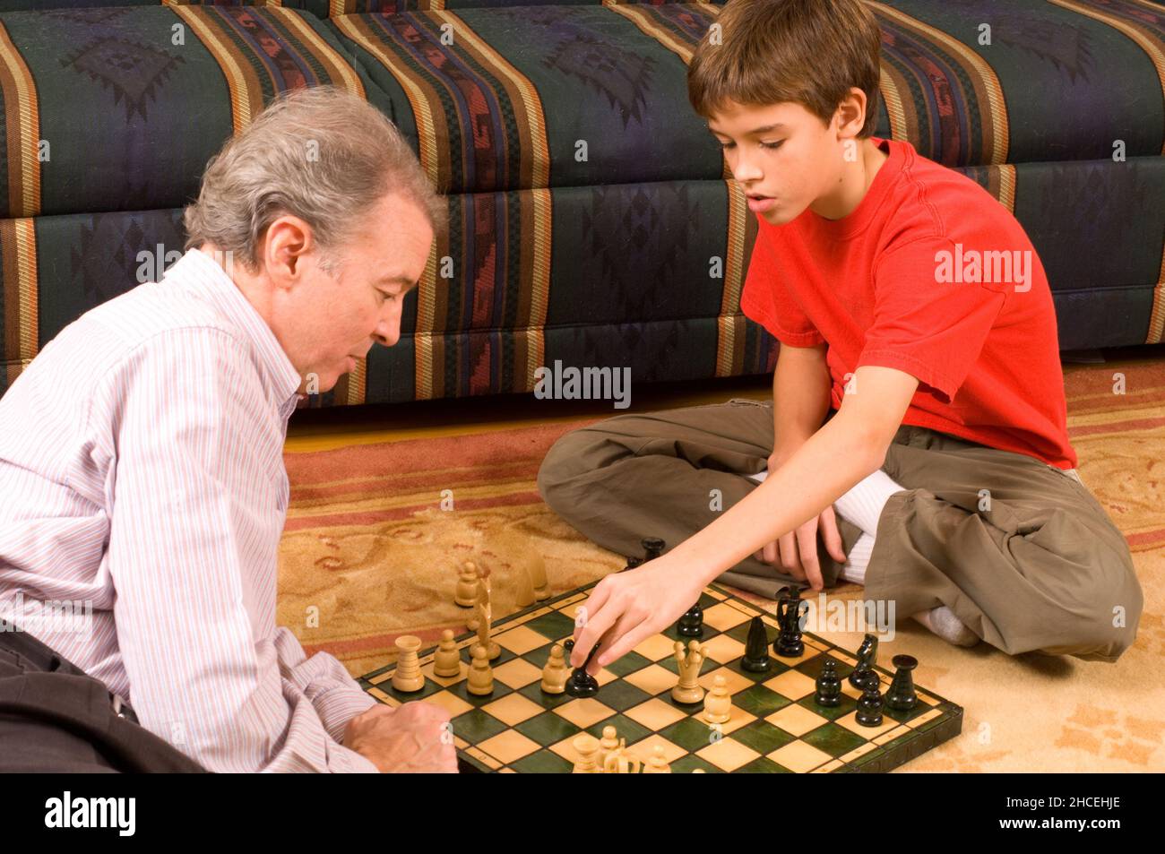 Father playing chess with 12 year old son, boy making move Stock Photo ...