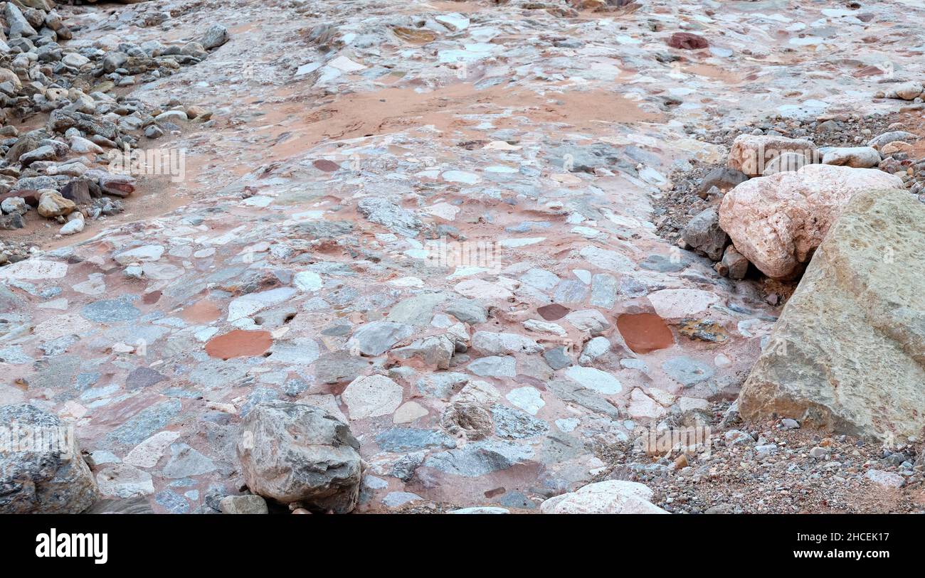 Conglomerate rock with large clasts eroded to smooth surface in dry ...