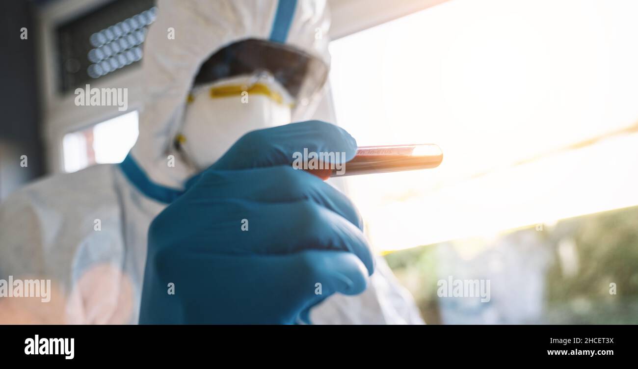 Researcher in protective clothing with test for Covid-19 positive with ...
