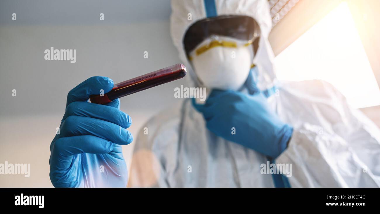 Medic in protective clothing with blood sample for Covid-19 test for ...
