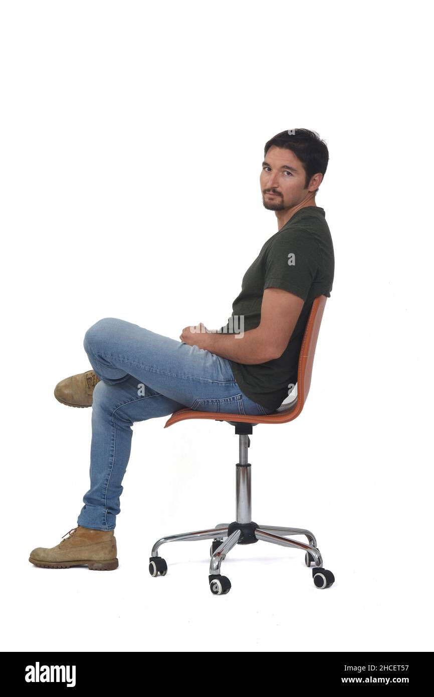side view of a full portrait of man sitting on chair looking at camera ...