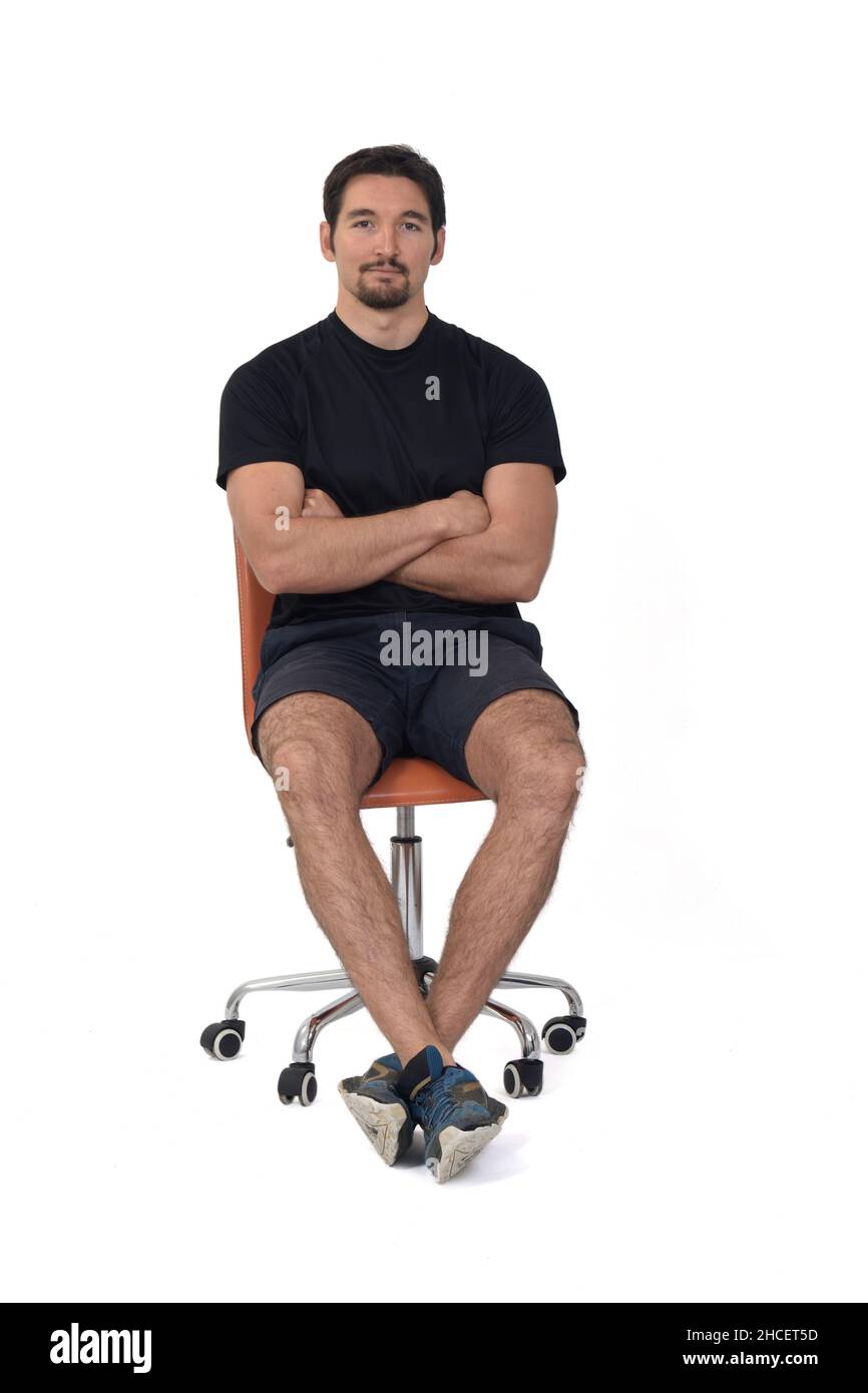 front view of a full portrait of a man sitting on a chair, arms crossed ...