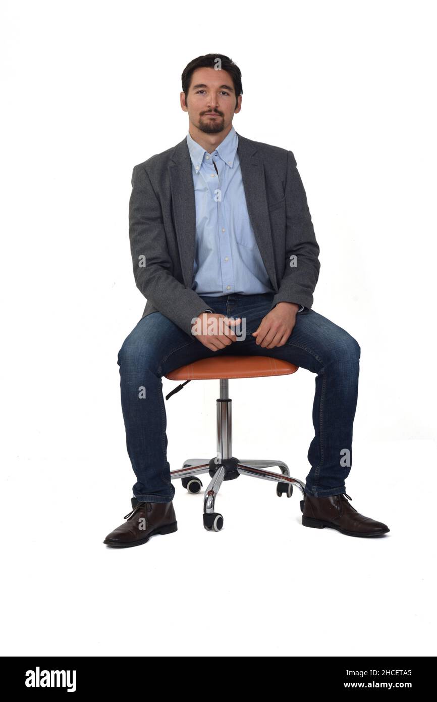 front view of a man sitting on chair, looking at camera on white ...