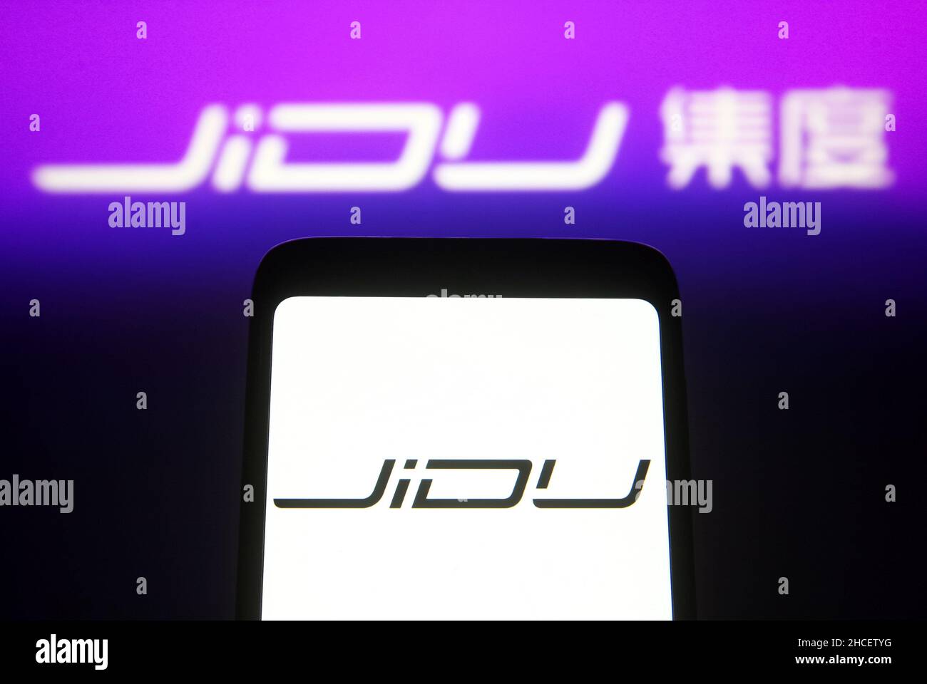 In this photo illustration, Jidu Auto logo is seen on a smartphone and in the background Stock ...