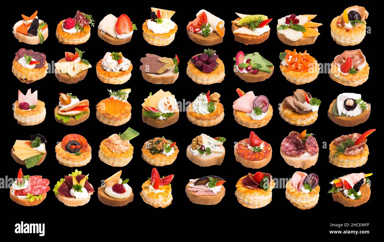 Canapes with different berries and toppings isolated on a black ...