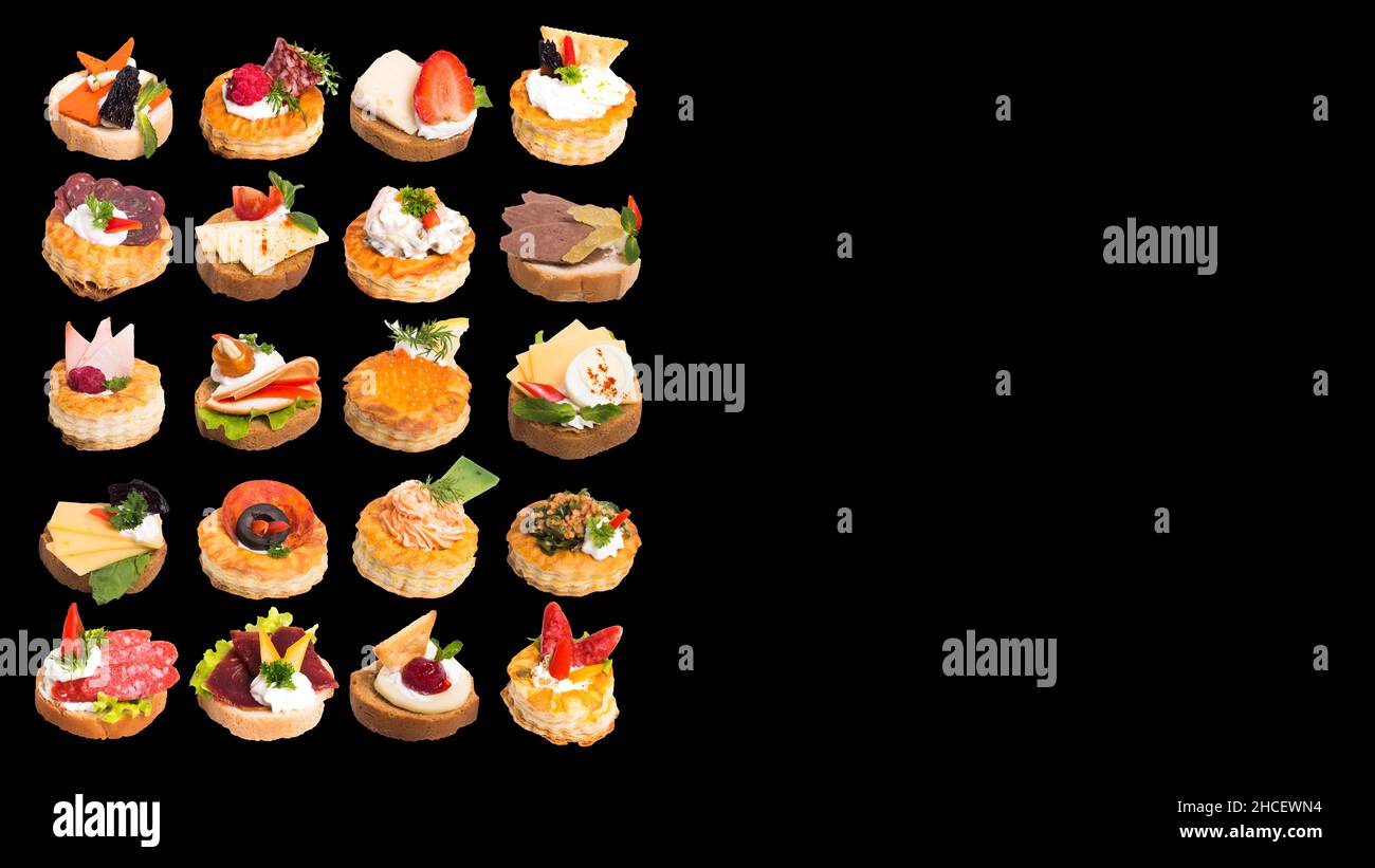 Canapes with different berries and toppings isolated on a black ...