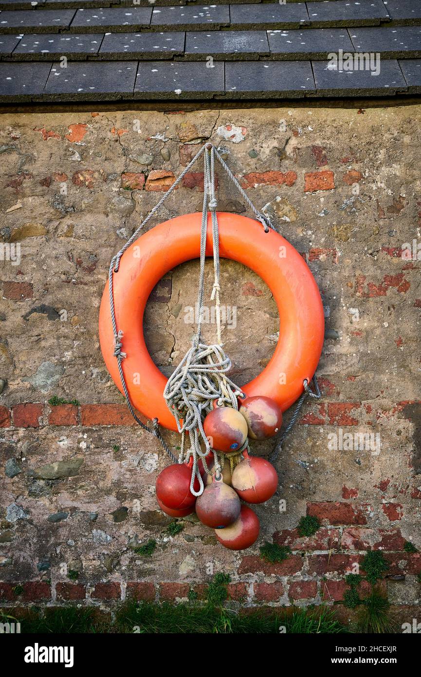 Lifebelt and floats hanging on a boathouse wall Stock Photo - Alamy