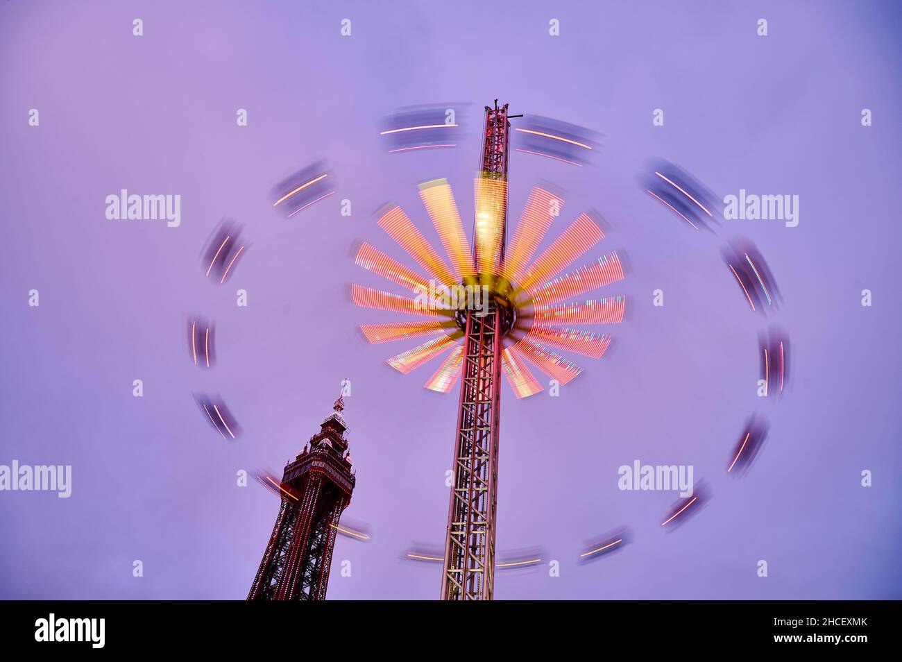 The Star Flyer ride and Blackpool Tower at dusk Stock Photo - Alamy
