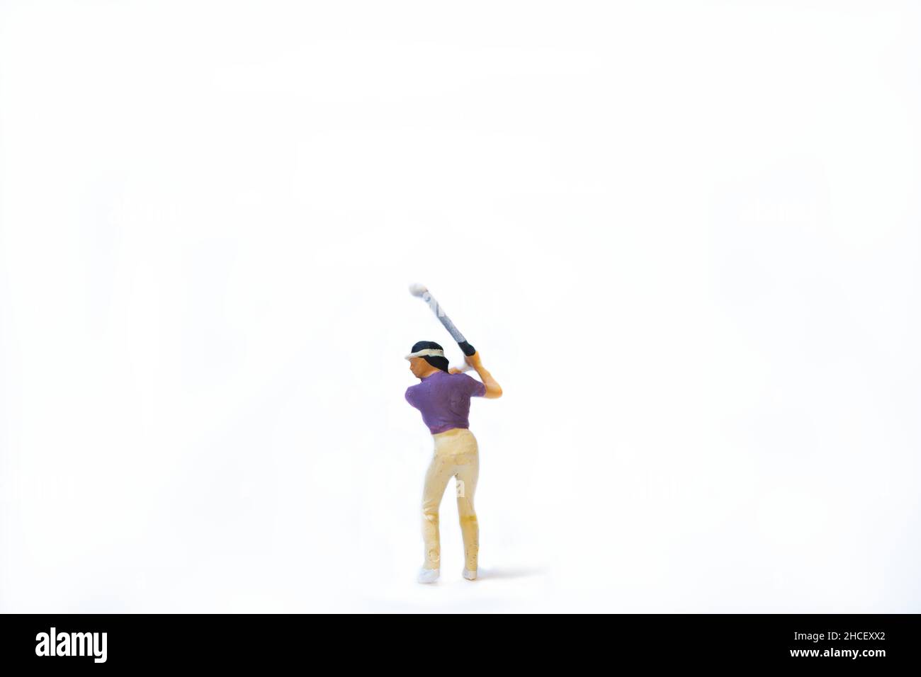Small miniature golfer in action position isolated on a white ...