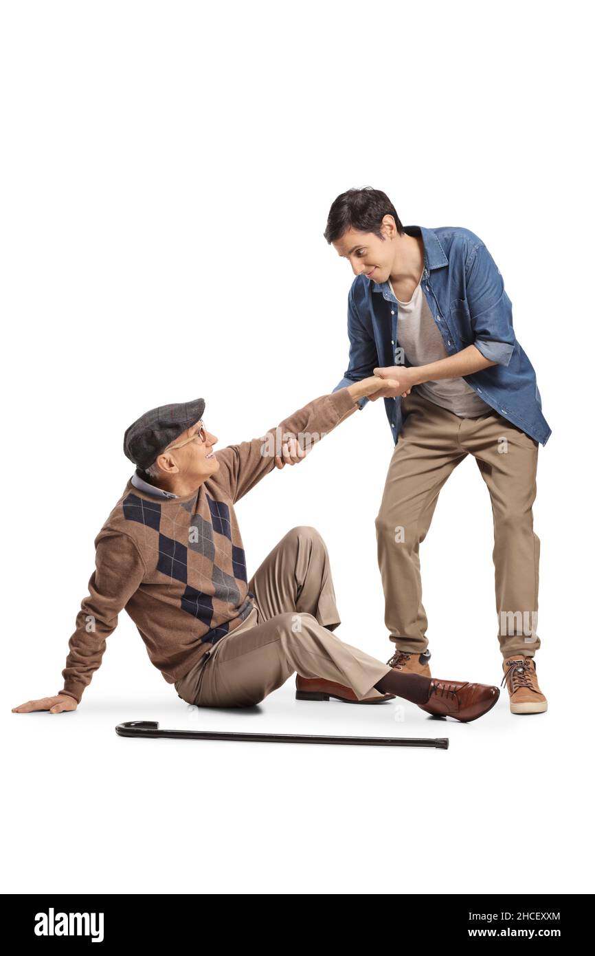 Young man helping an elderly man with a cane seated on the floor ...
