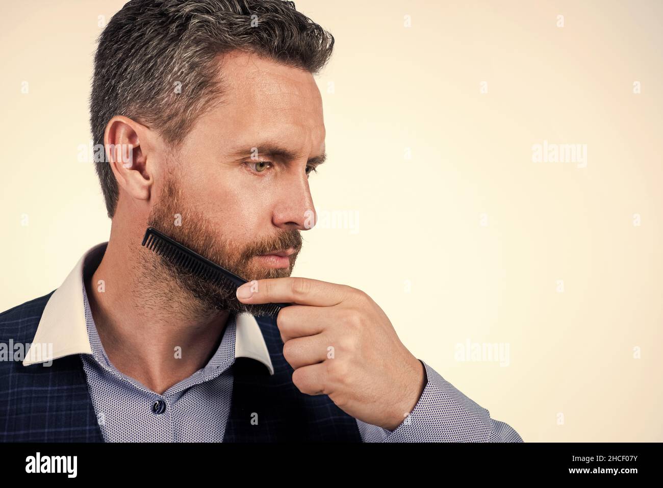 handsome hairstylist brushing hair with hair brush. barbershop. confident guy grooming Stock ...