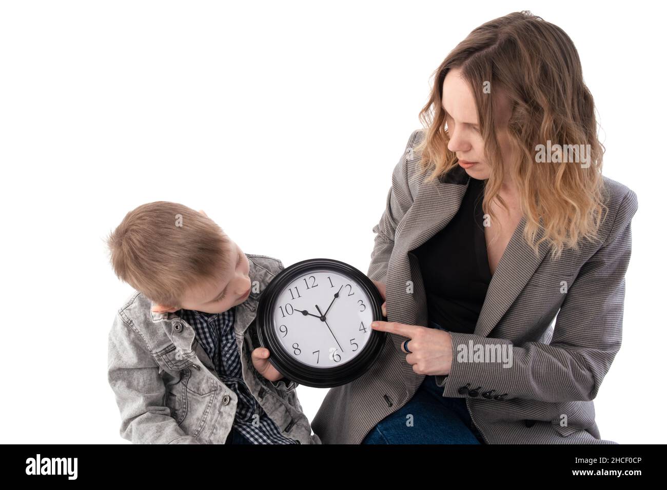 Schoolboy mom and son are studying the clock. Isolated over white ...