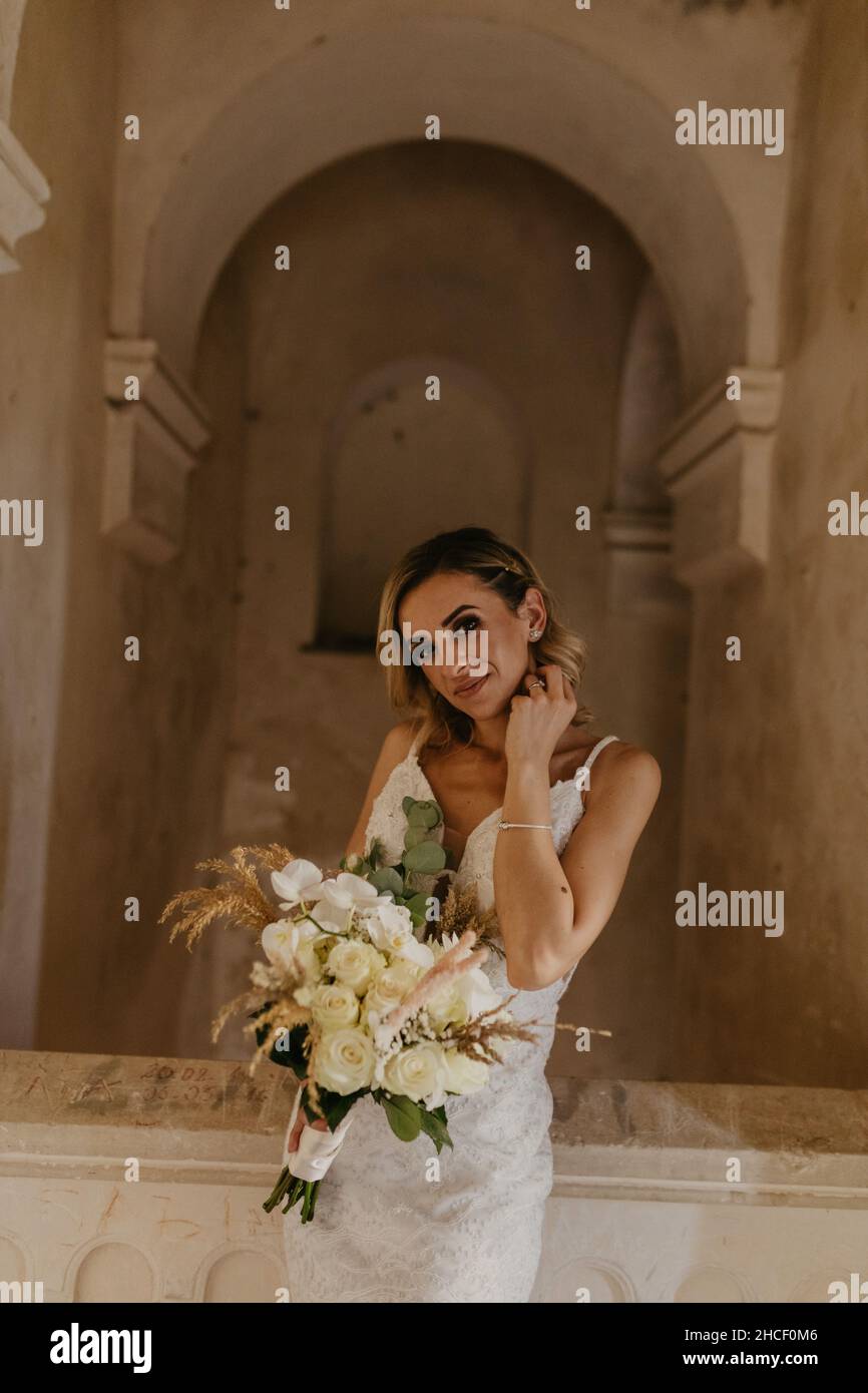 Beautiful Middle Eastern bride in her white wedding dress posing with a ...