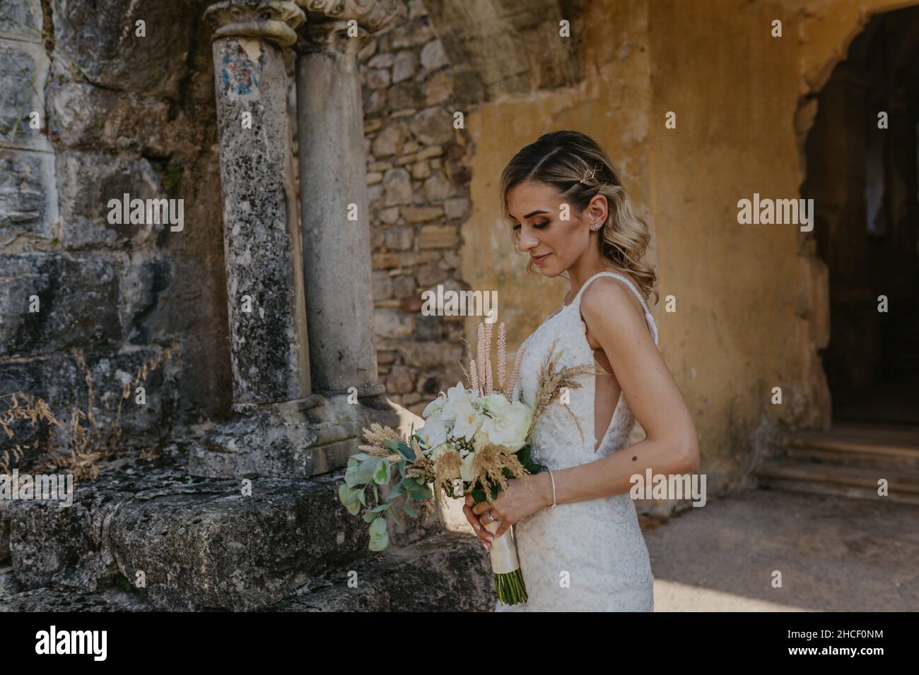 Beautiful Middle Eastern bride in her white wedding dress posing with a ...