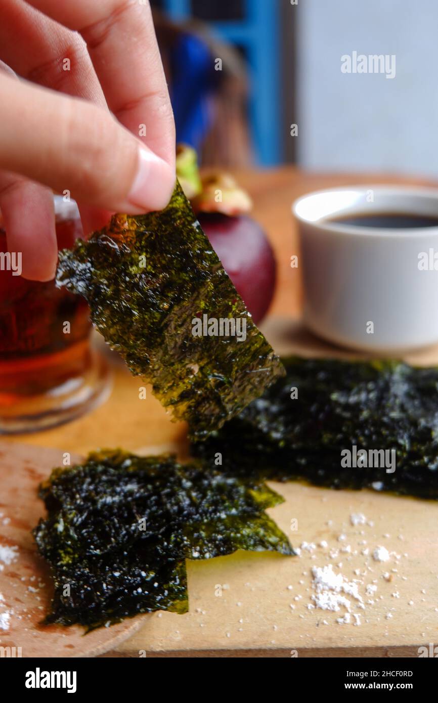 Photo of chopped seaweed and a cup of coffee and mangosteen beside it ...
