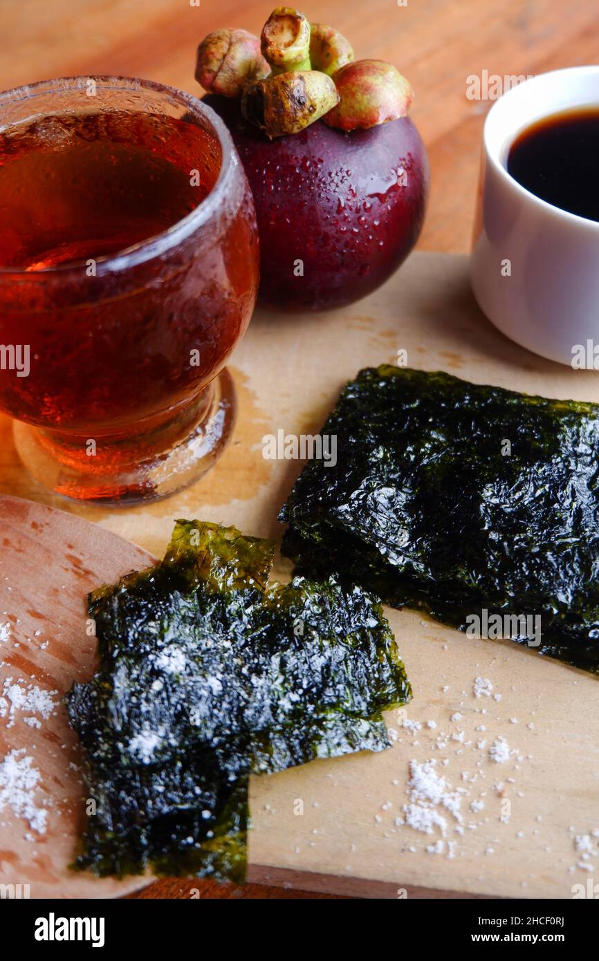 Photo of chopped seaweed and a cup of coffee and mangosteen beside it ...