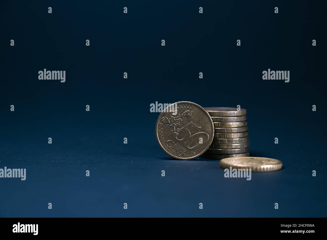 50 Euro cents on a blue background. A fifty cent coin stands beautiful ...