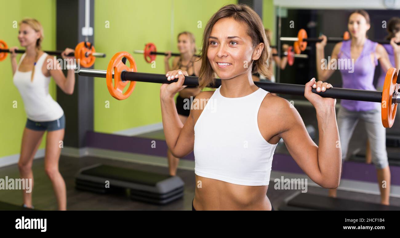 Group of athletic young women exercising weight lifting Stock Photo - Alamy