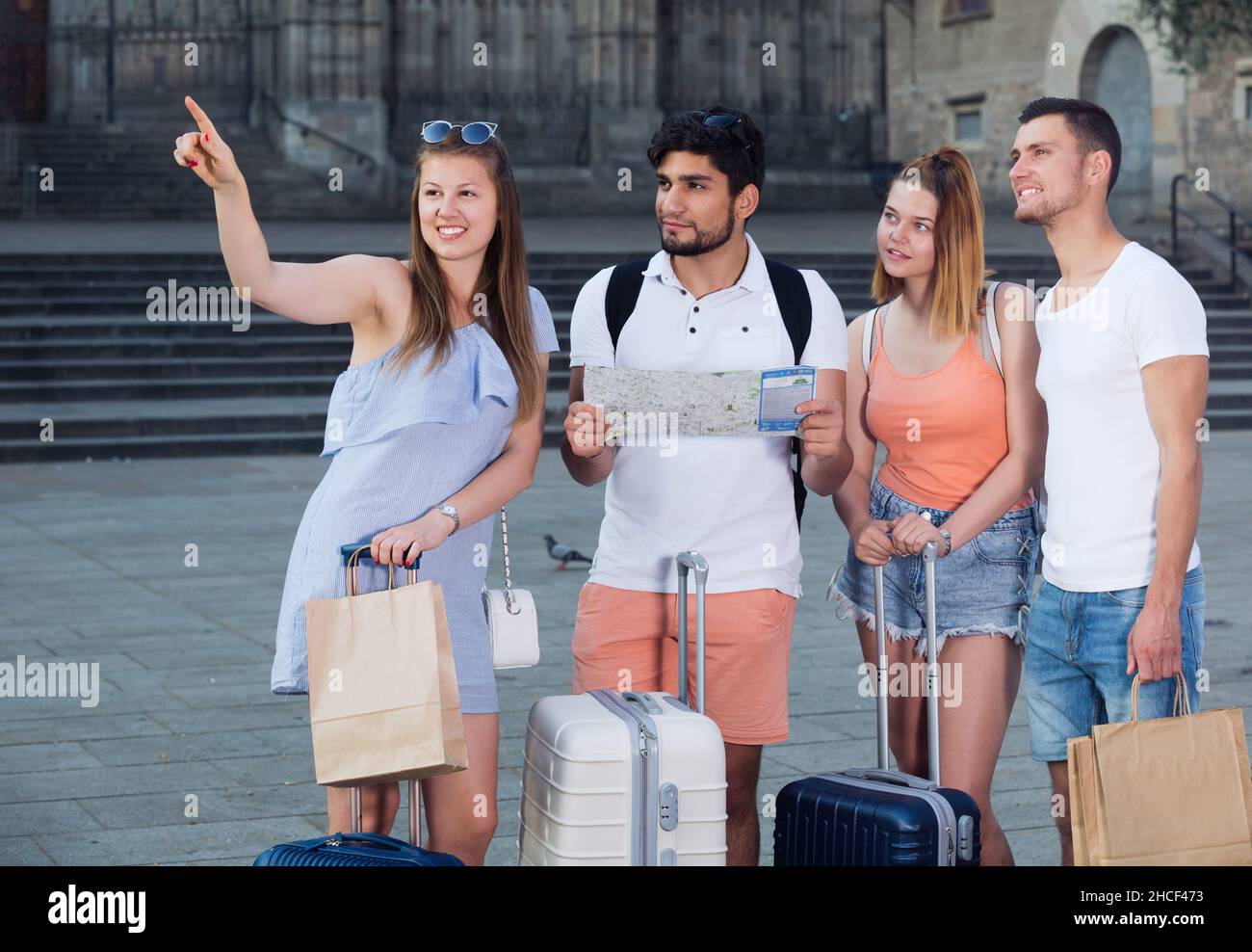 Group of young traveling people using paper map in city Stock Photo - Alamy