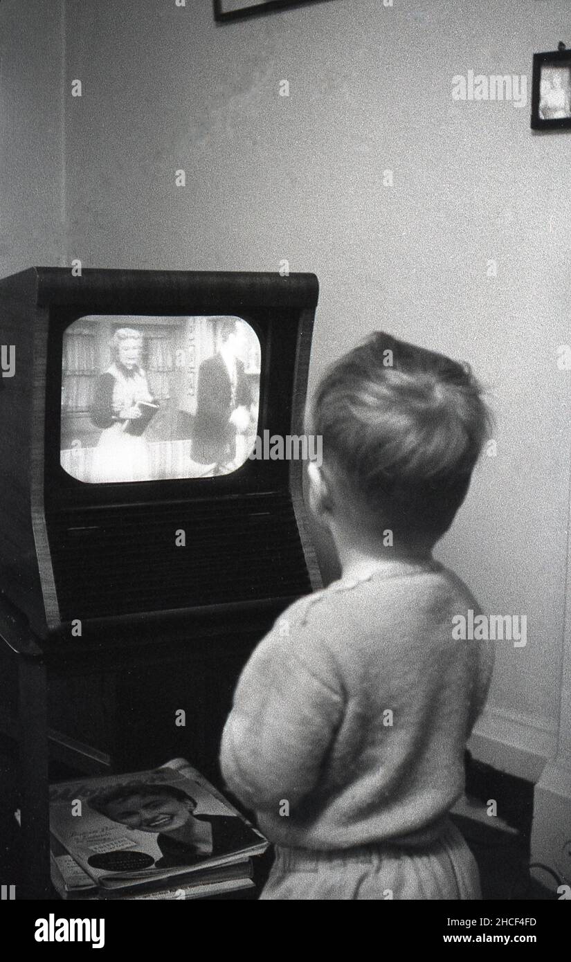 Late 1950s, historical, a little boy standing close to a small ...