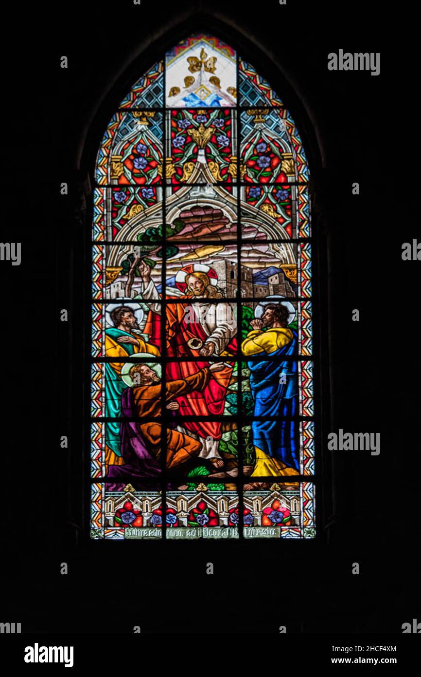 Vertical shot of a Gothic stained glass of a church on the black ...