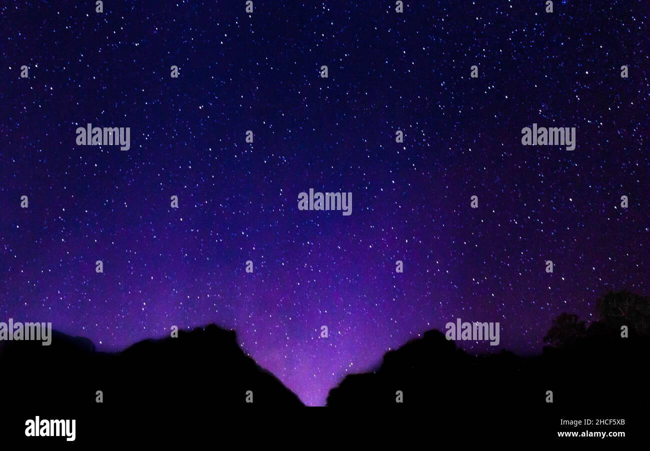 Night sky with lot of shiny stars with blurred mountain background ...