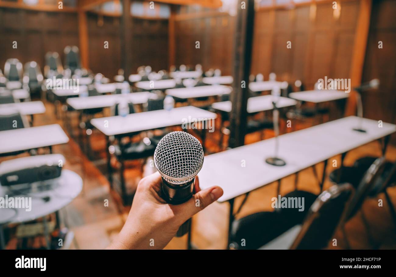 Close-up microphone with blurred people attending seminar background ...