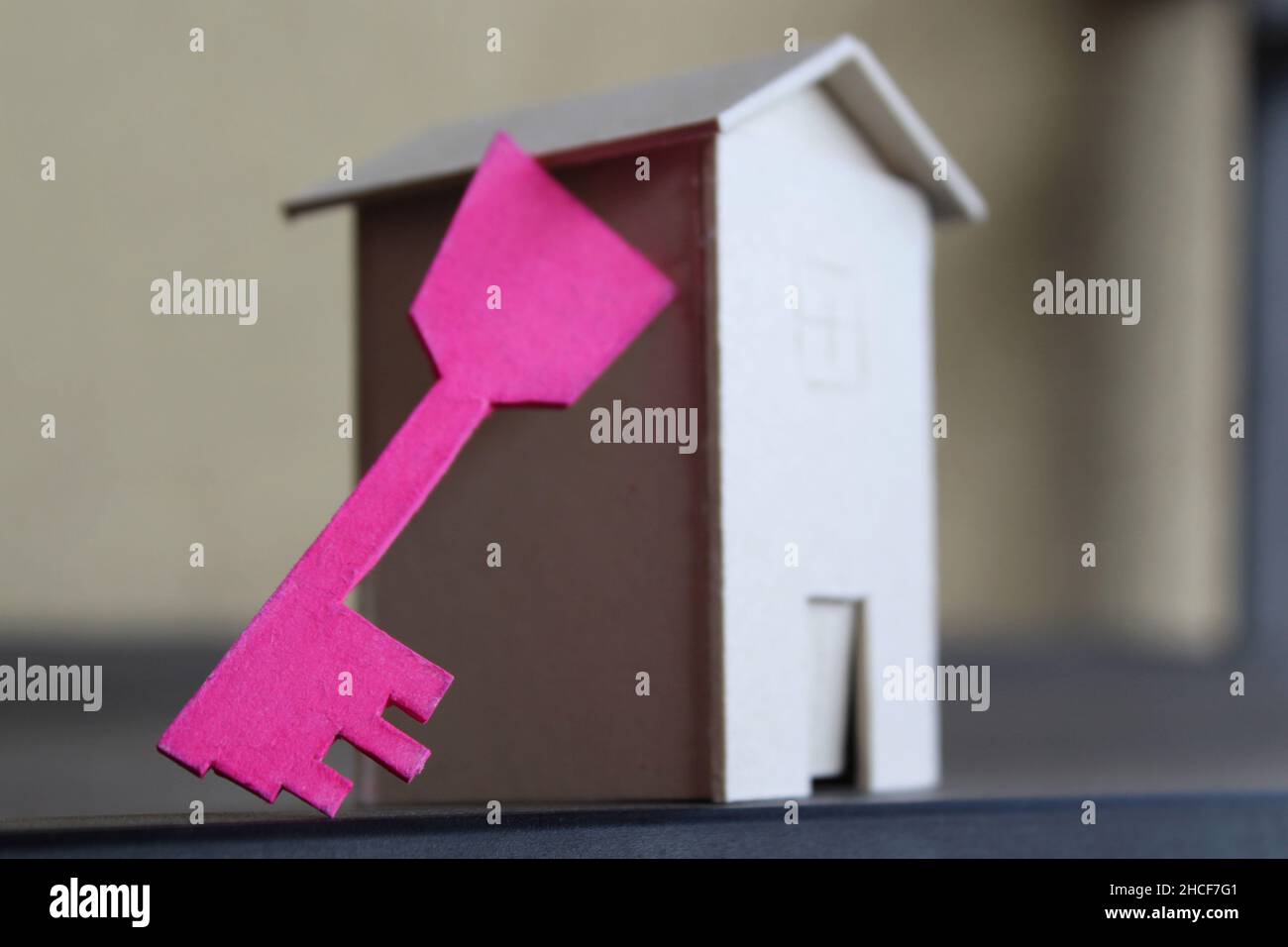 Cardboard house with a pink key on the table Stock Photo - Alamy