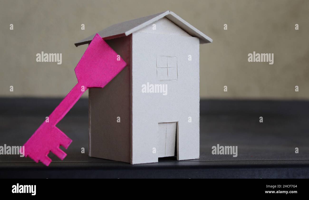 Cardboard house with a pink key on the table Stock Photo - Alamy