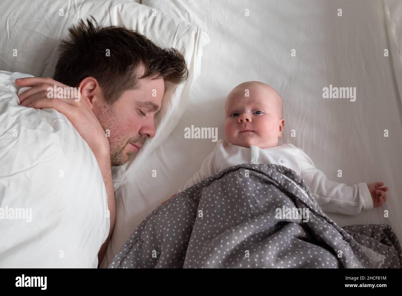 Sleeping father and cute child resting together in bed Stock Photo - Alamy