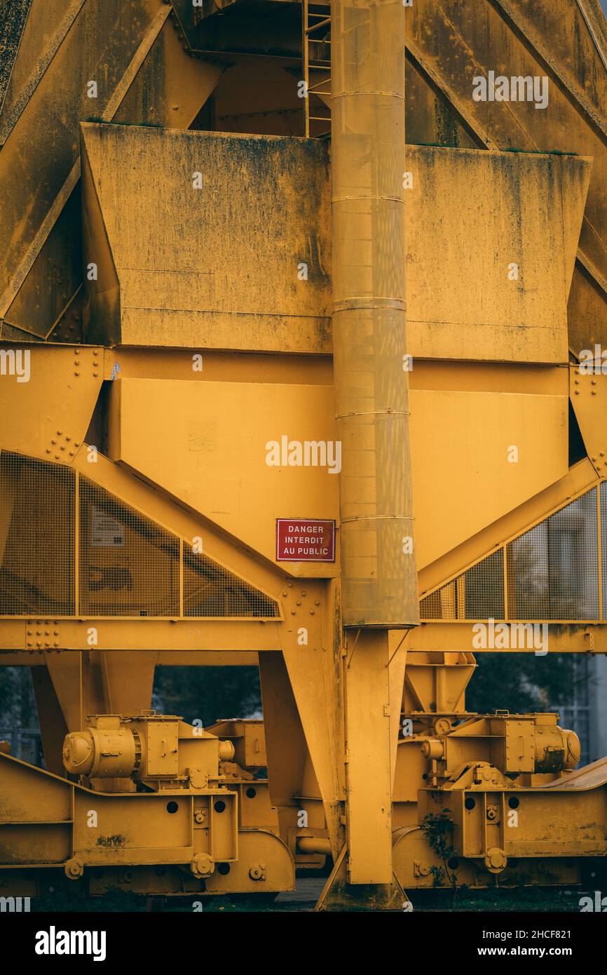 Vertical shot of a yellow machine with a sign Danger, Forbidden to the ...