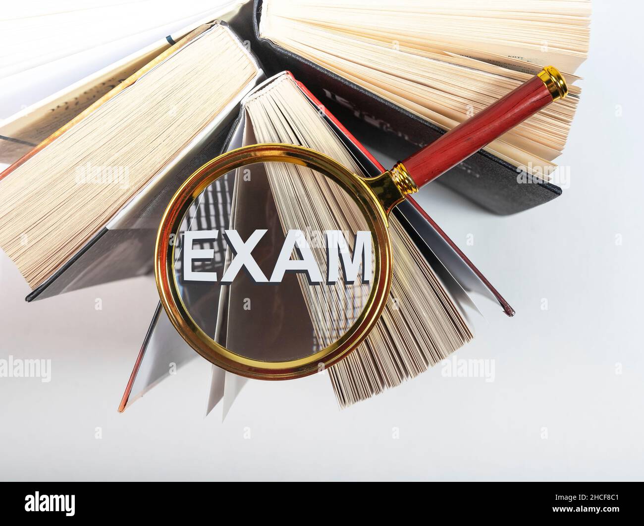 Exam word. Concept of examination preparation with books and magnify ...