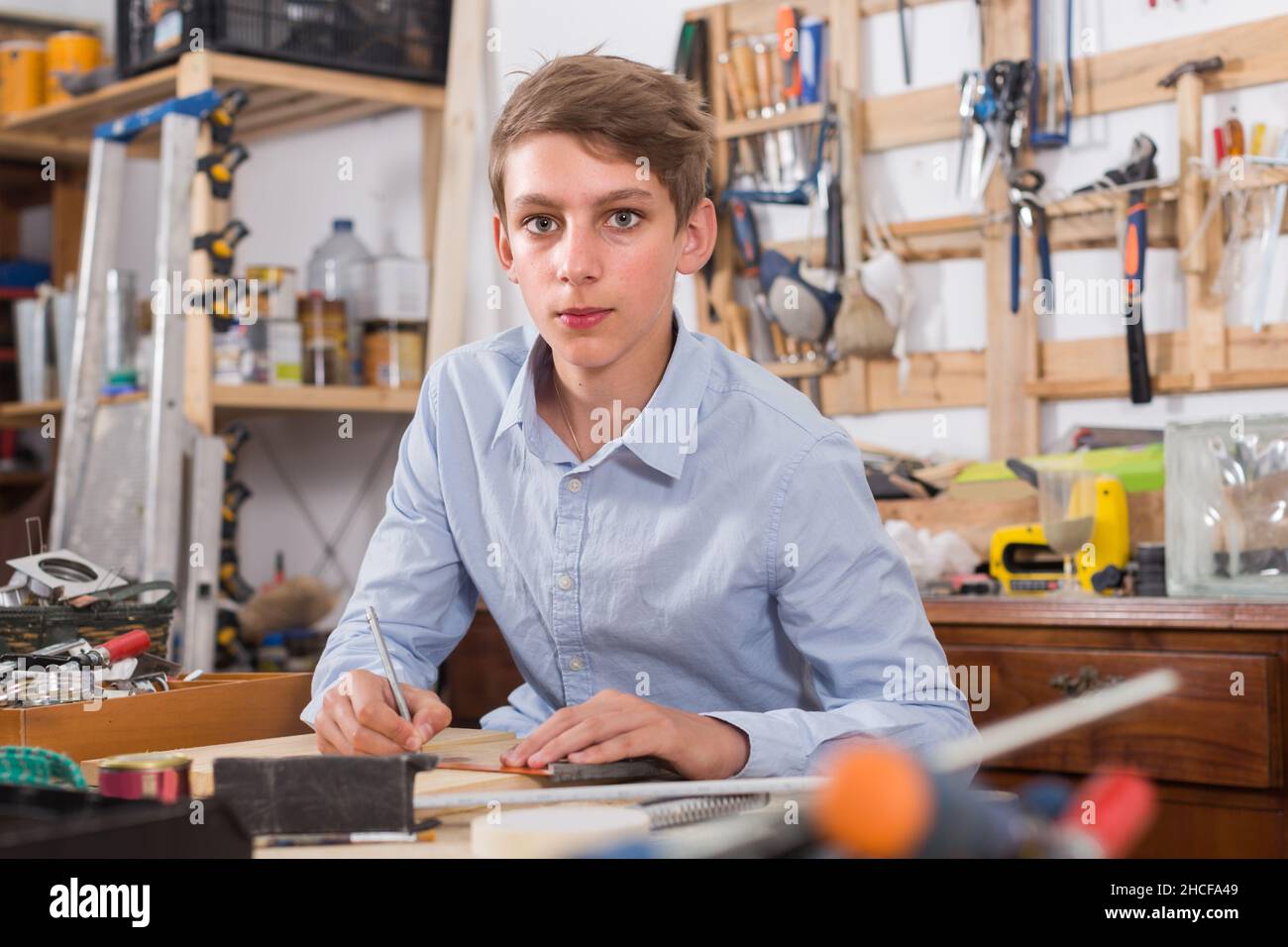 teenager smiling and working with wood in the workshop Stock Photo - Alamy