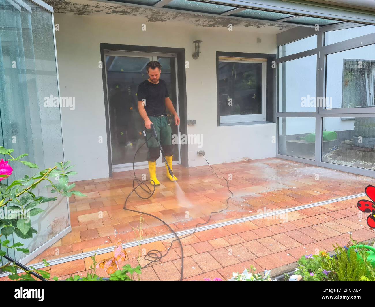 Man cleaning conservatory with a pressure washer - high pressure washer ...
